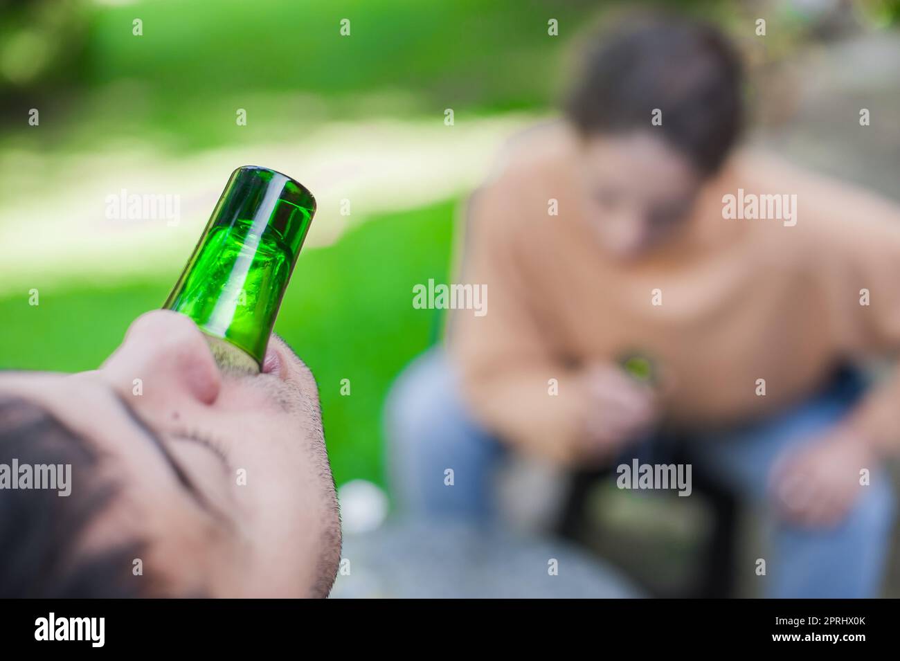 Very drunk couple, a boy and a girl, drink a strong alcoholic shot drink from small glasses. Bad ...