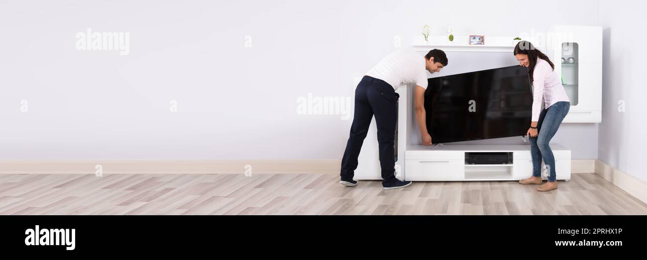 Happy Buying Television. Holding TV Screen At Home Stock Photo - Alamy