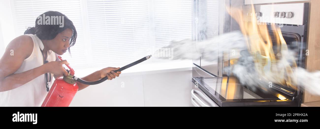 Using Fire Extinguisher In Kitchen. Oven Safety Disaster Stock Photo ...
