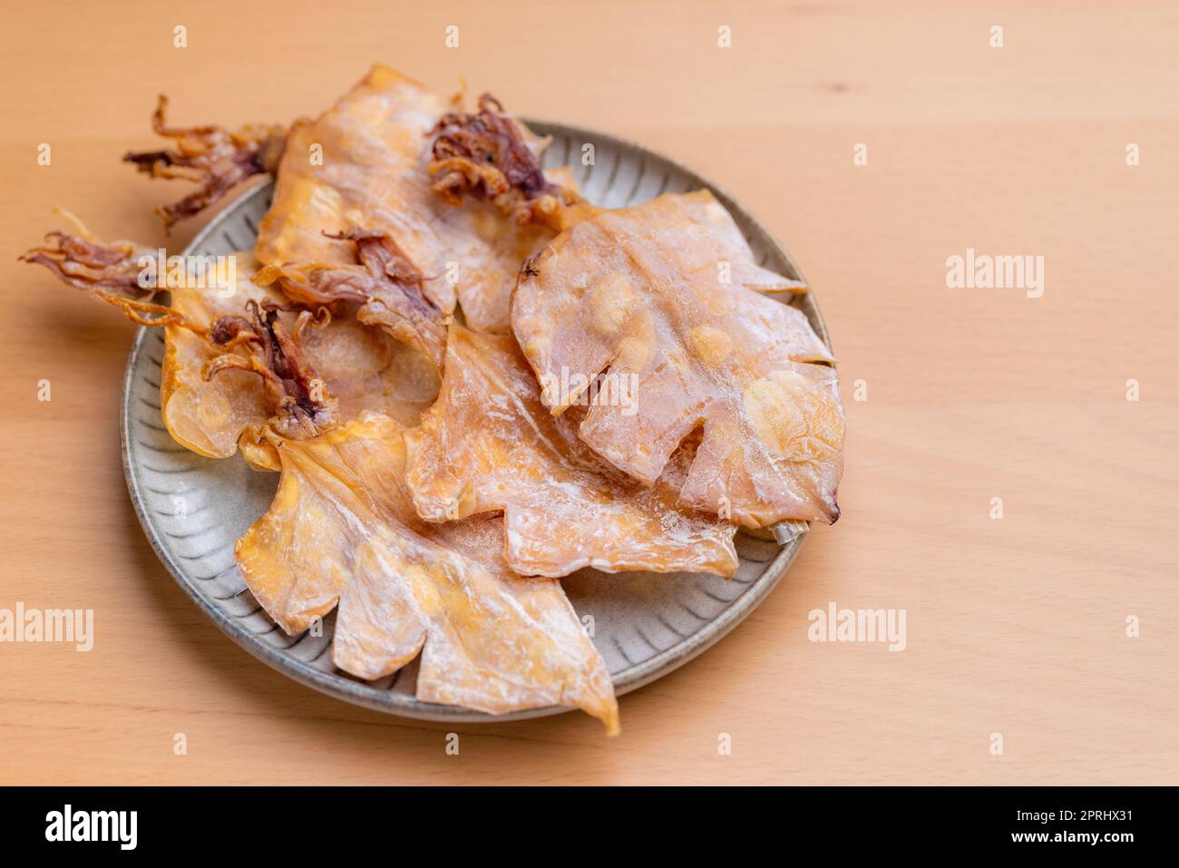 Dried squid snack in the plate Stock Photo - Alamy