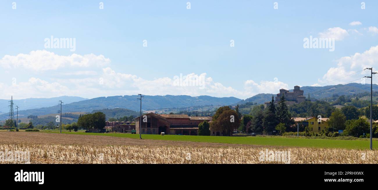 Crop field and mountain landscape with the castle of Torrechiara, Parma ...