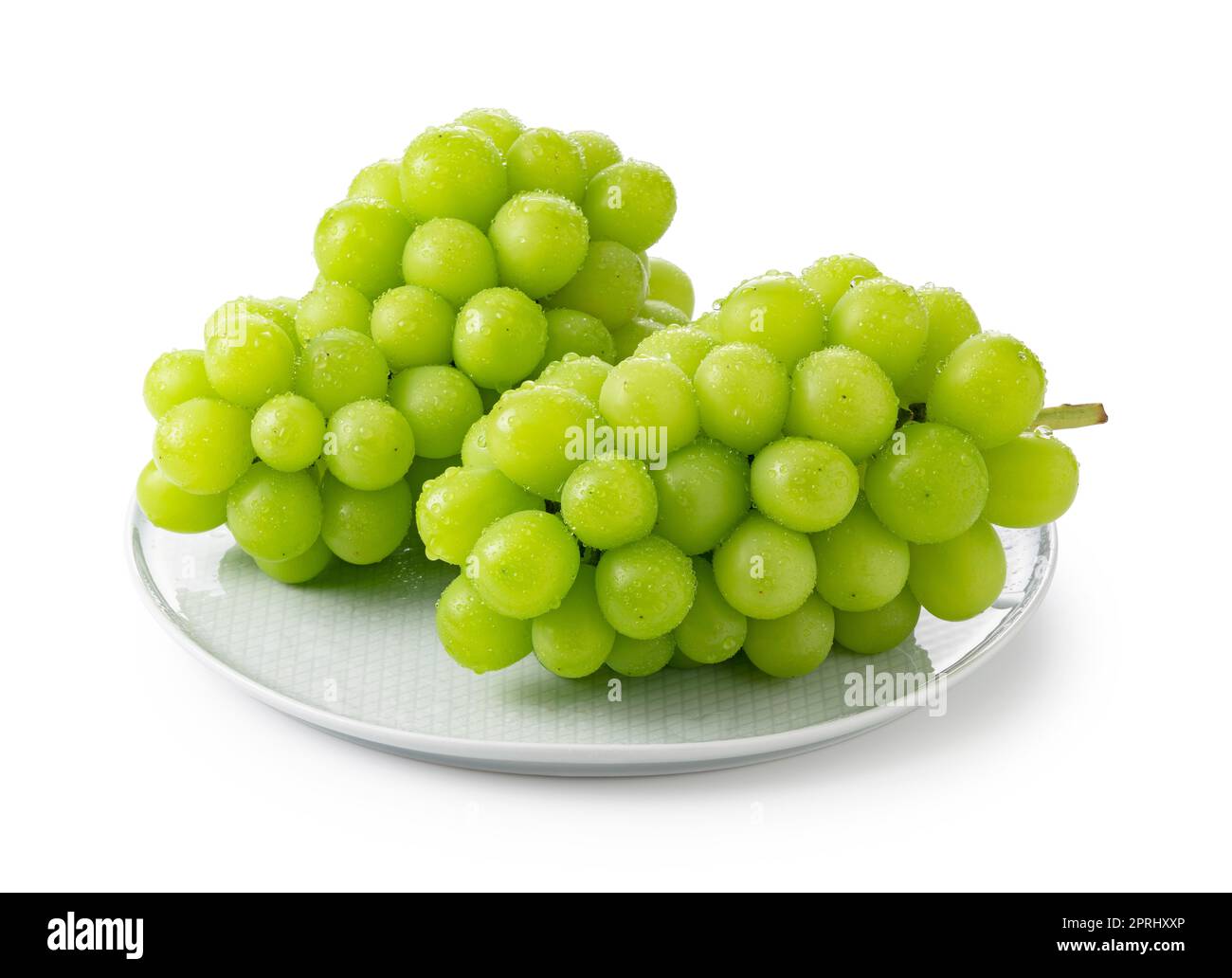 Shine Muscat with water droplets placed on a plate against a white ...