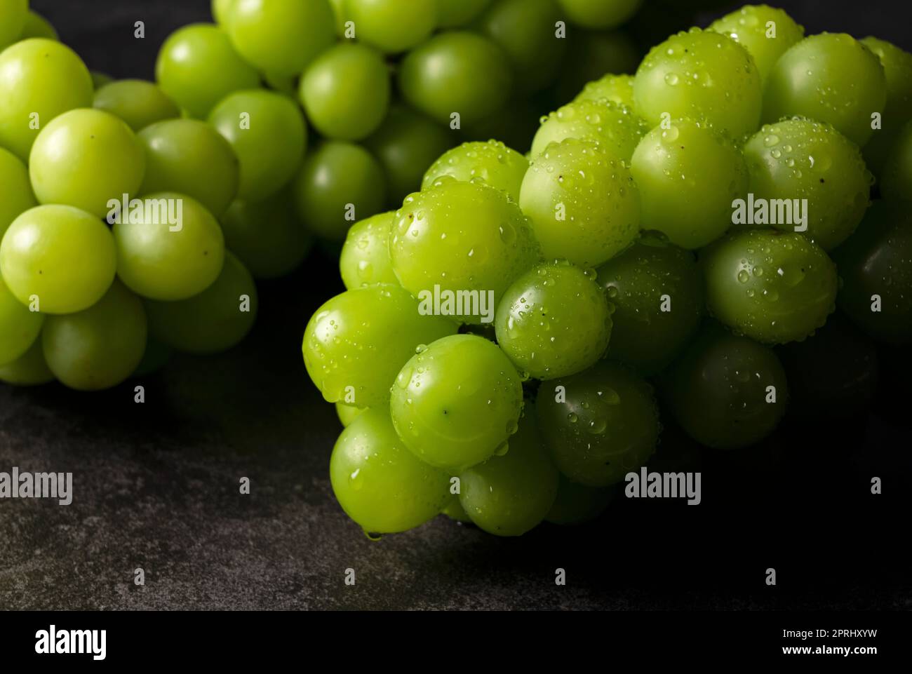 Shine Muscat with water droplets placed on black background. White ...