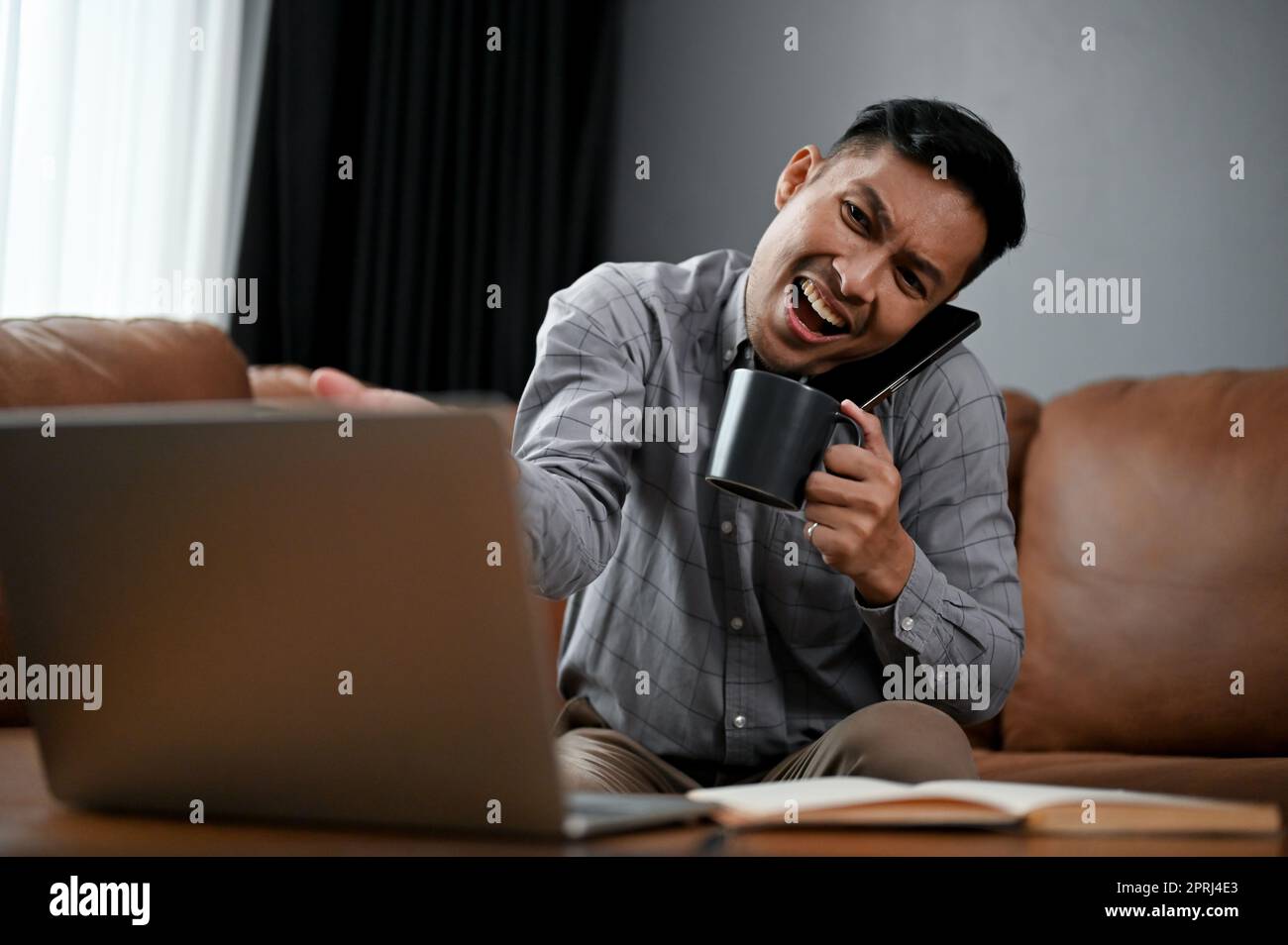 Busy and furious millennial Asian businessman working from home ...