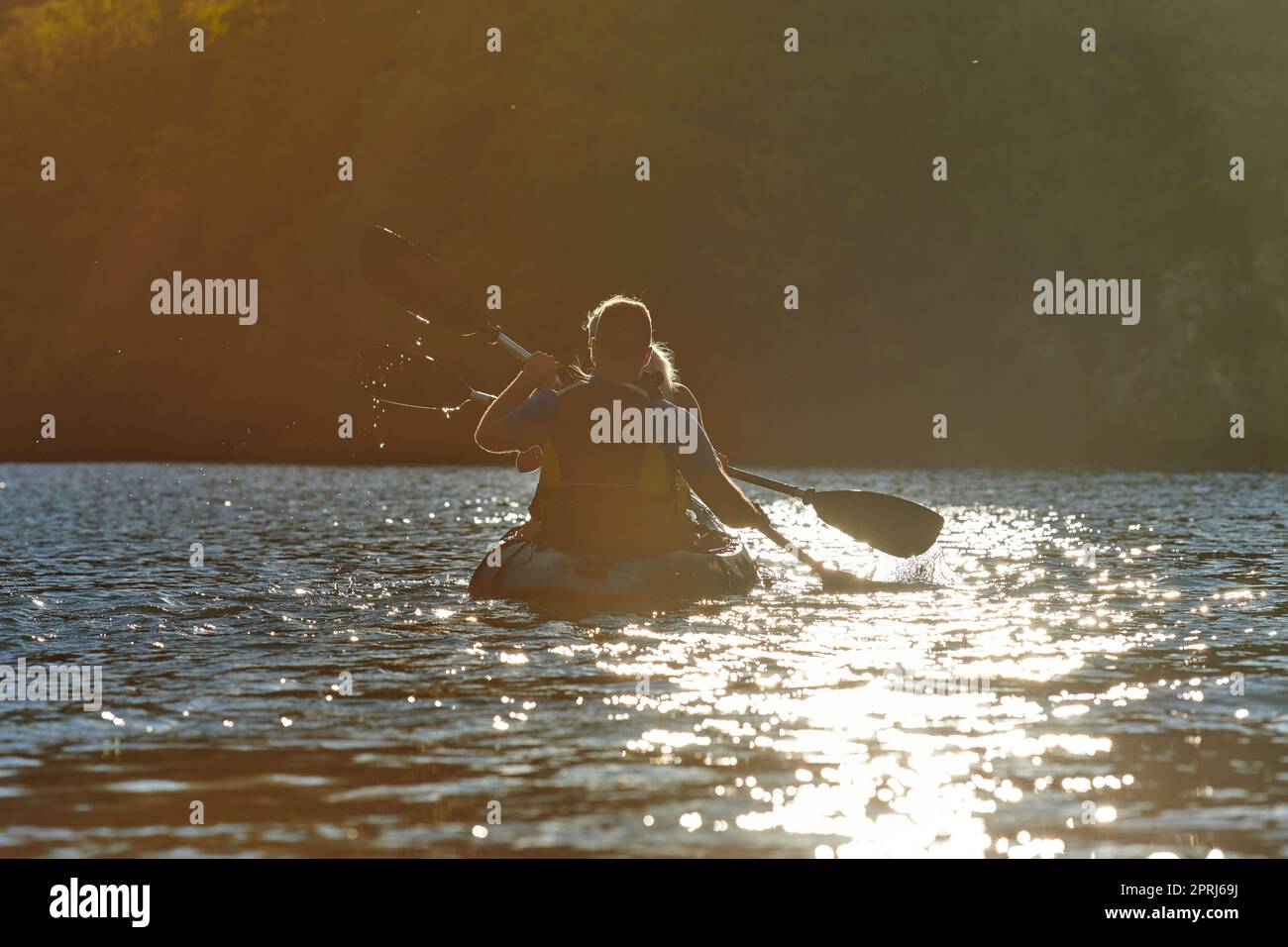 A young couple enjoying an idyllic kayak ride in the middle of a ...