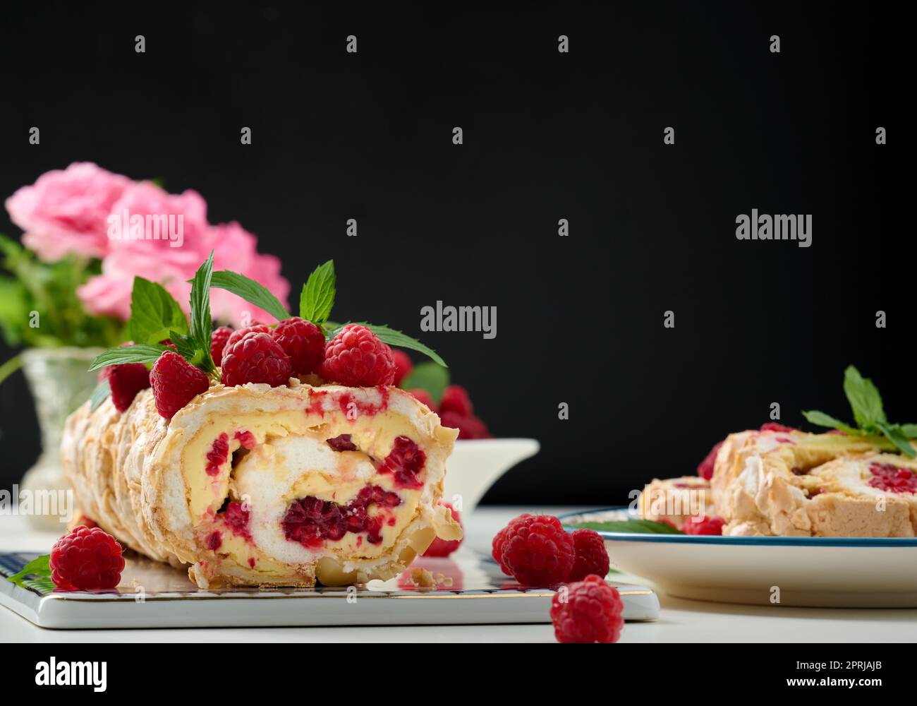Baked meringue roll with cream and fresh red raspberry Stock Photo - Alamy