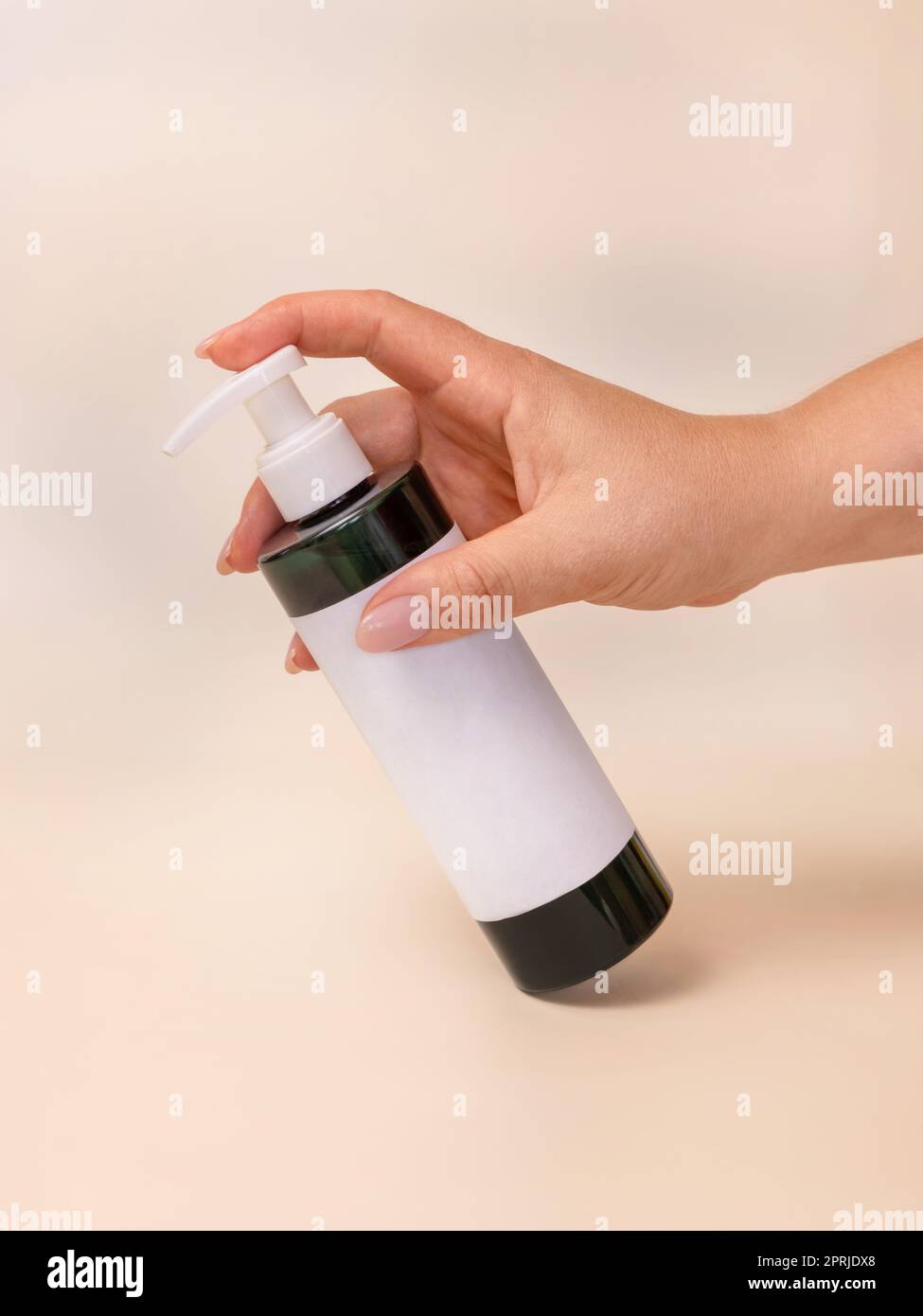 A woman hand pumping disinfectant liquid from a bottle with blank label ...