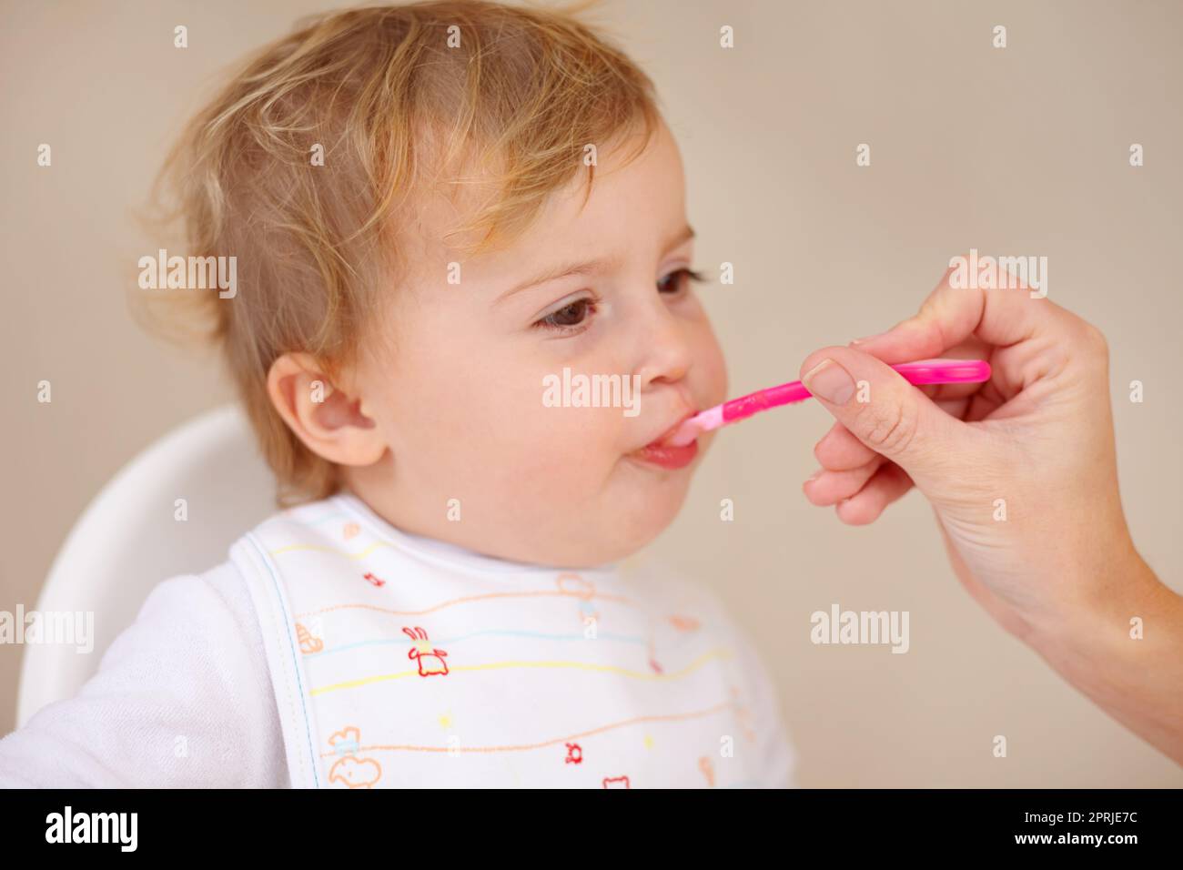 Its gonna help you grow up big. a baby being spoonfed by his mom Stock ...