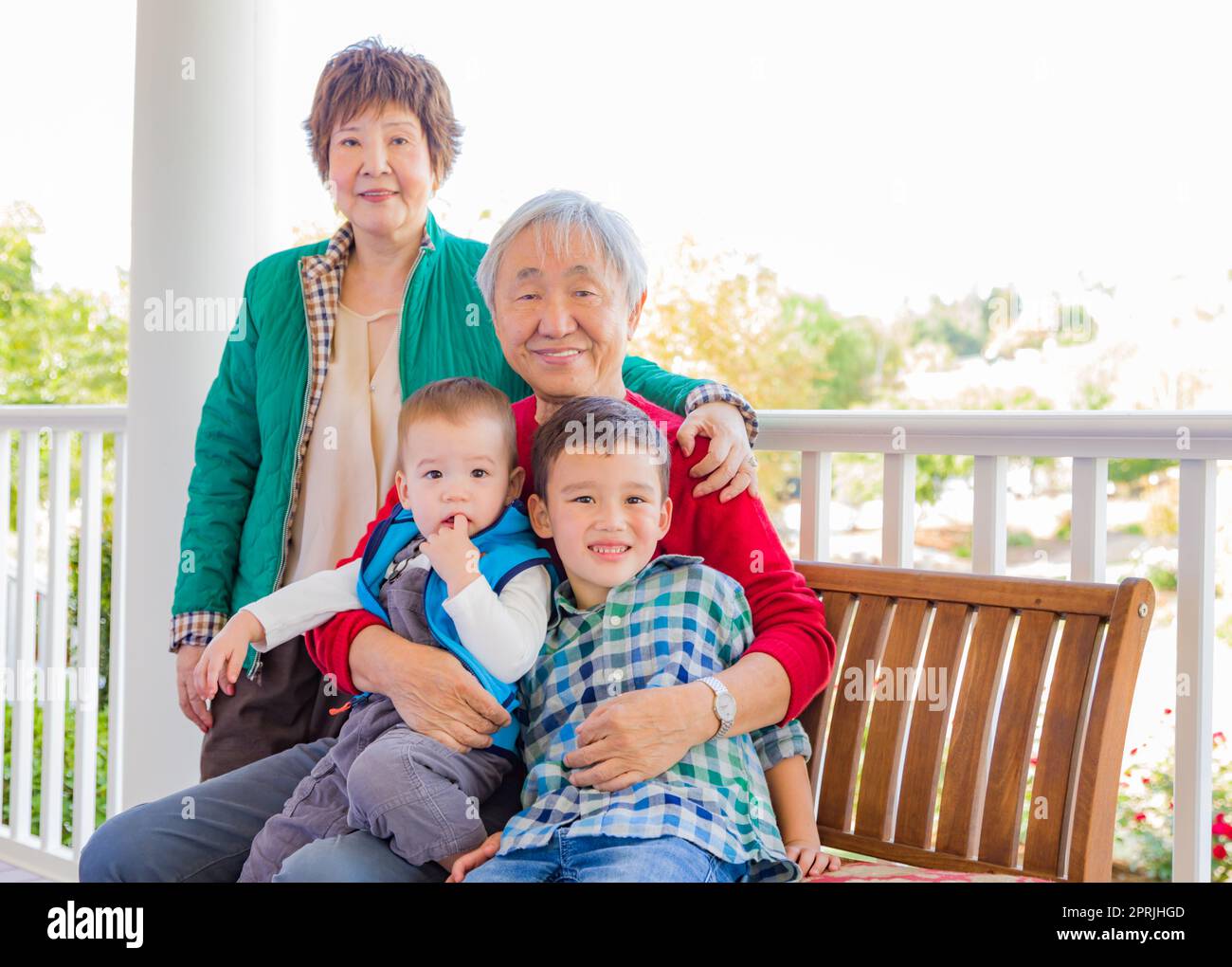 Senior Adult Chinese Couple Sitting With Their Mixed Race Grandchildren ...
