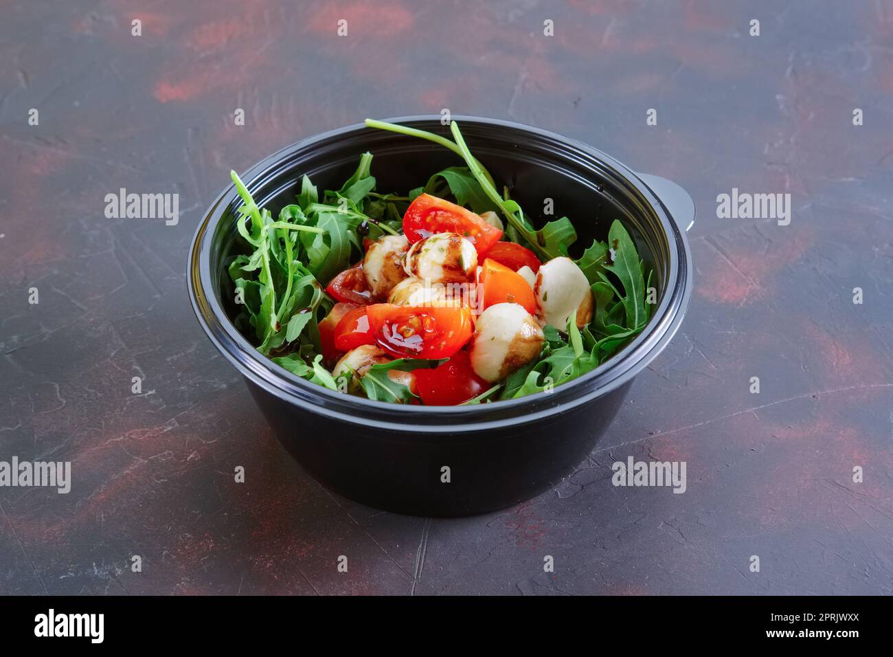 Salad with mozzarella, tomato and arugula in take away packaging Stock ...