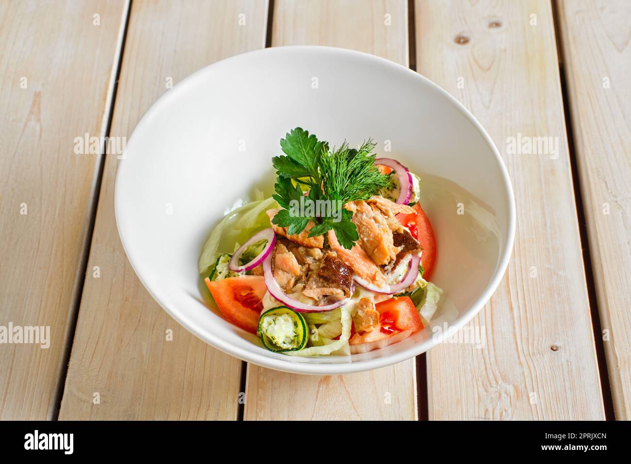 Salad with salmon, tomato, red onion and dorblu cheese Stock Photo - Alamy
