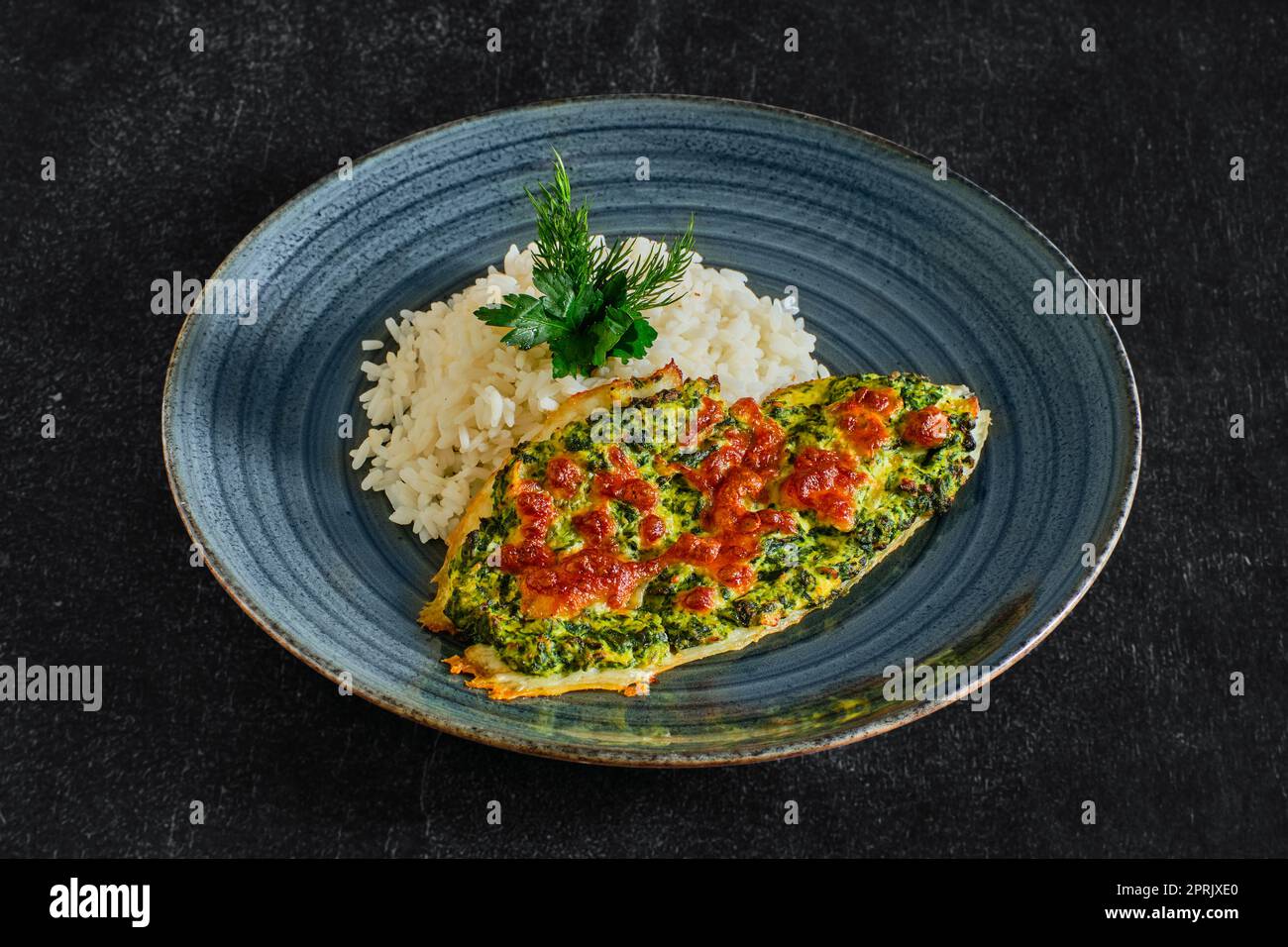 Fried fillet of white fish with spinach and cheese topping and served ...