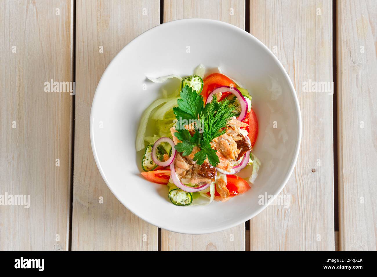 Top view of salad with salmon, tomato, red onion and dorblu cheese ...
