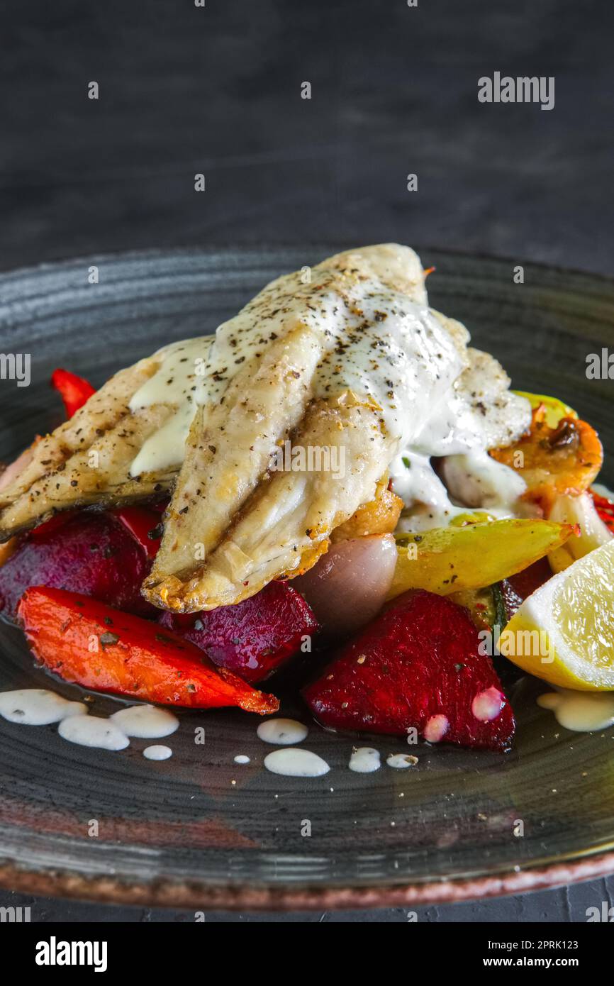 Fried fish fillet with grilled beetroot, carrot, bell pepper, zucchini ...