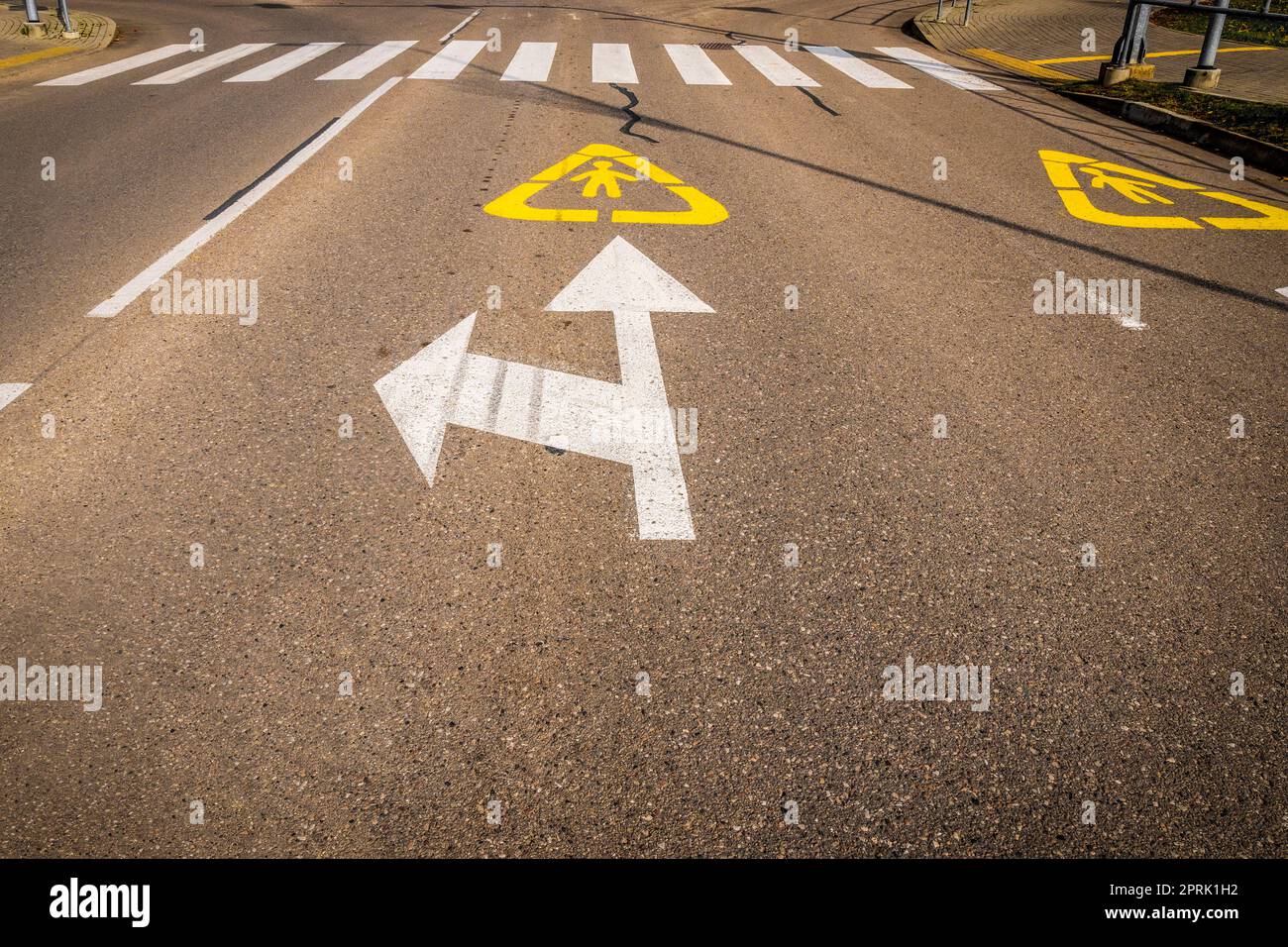Asphalt road with white arrows,crosswalk and sign KIDS painted on the ...