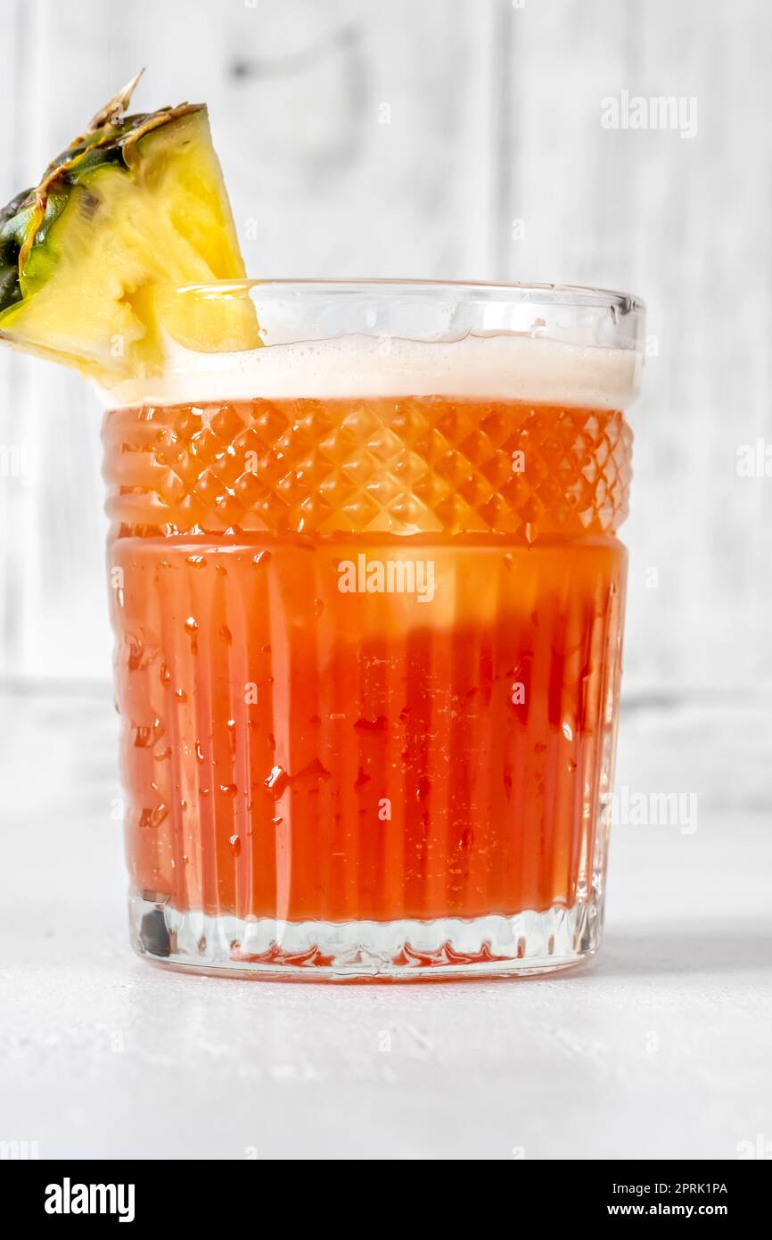 Glass of Jungle Bird cocktail garnished with pineapple wedge Stock ...