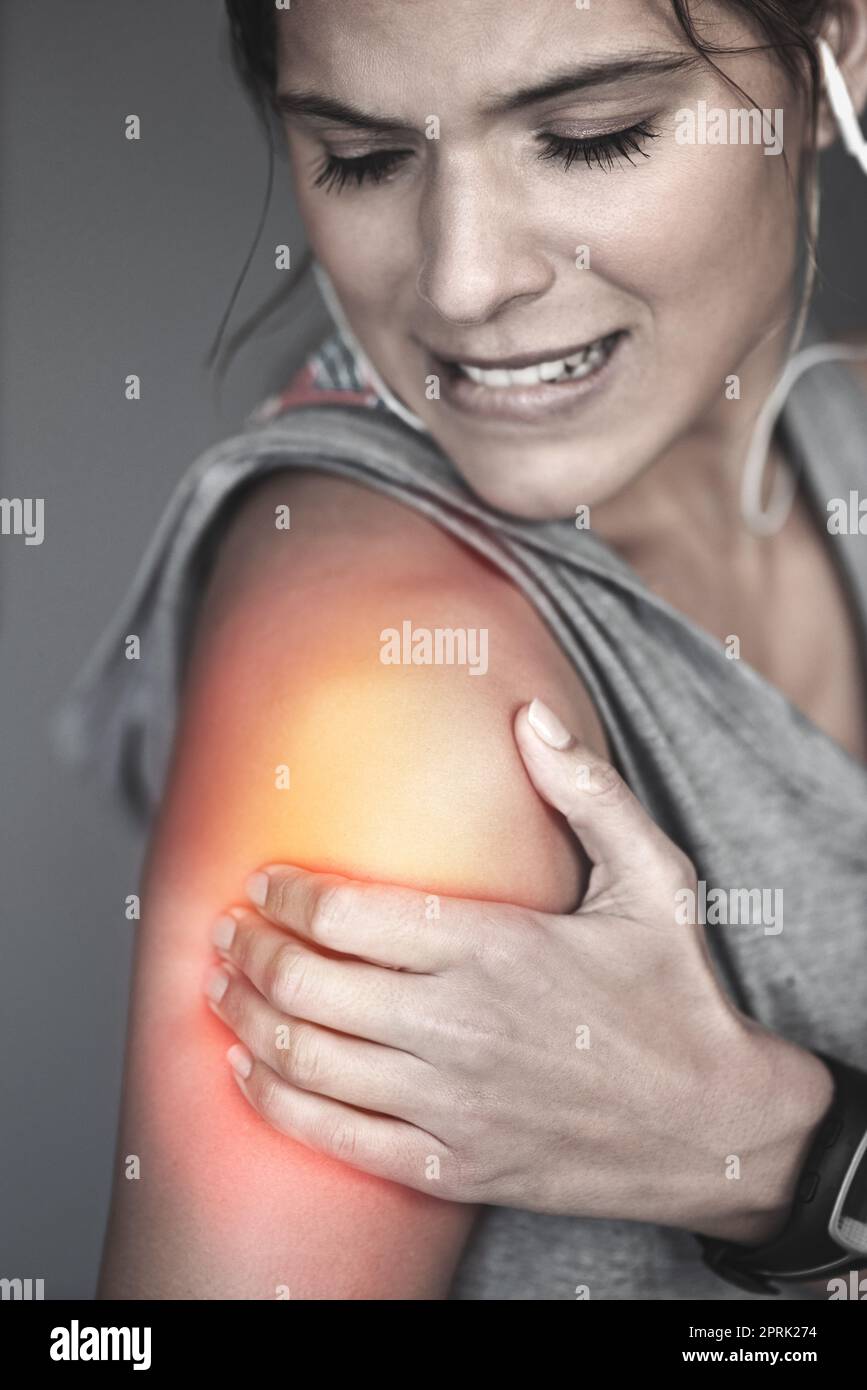 That really hurts. a young woman holding her injured shoulder thats ...