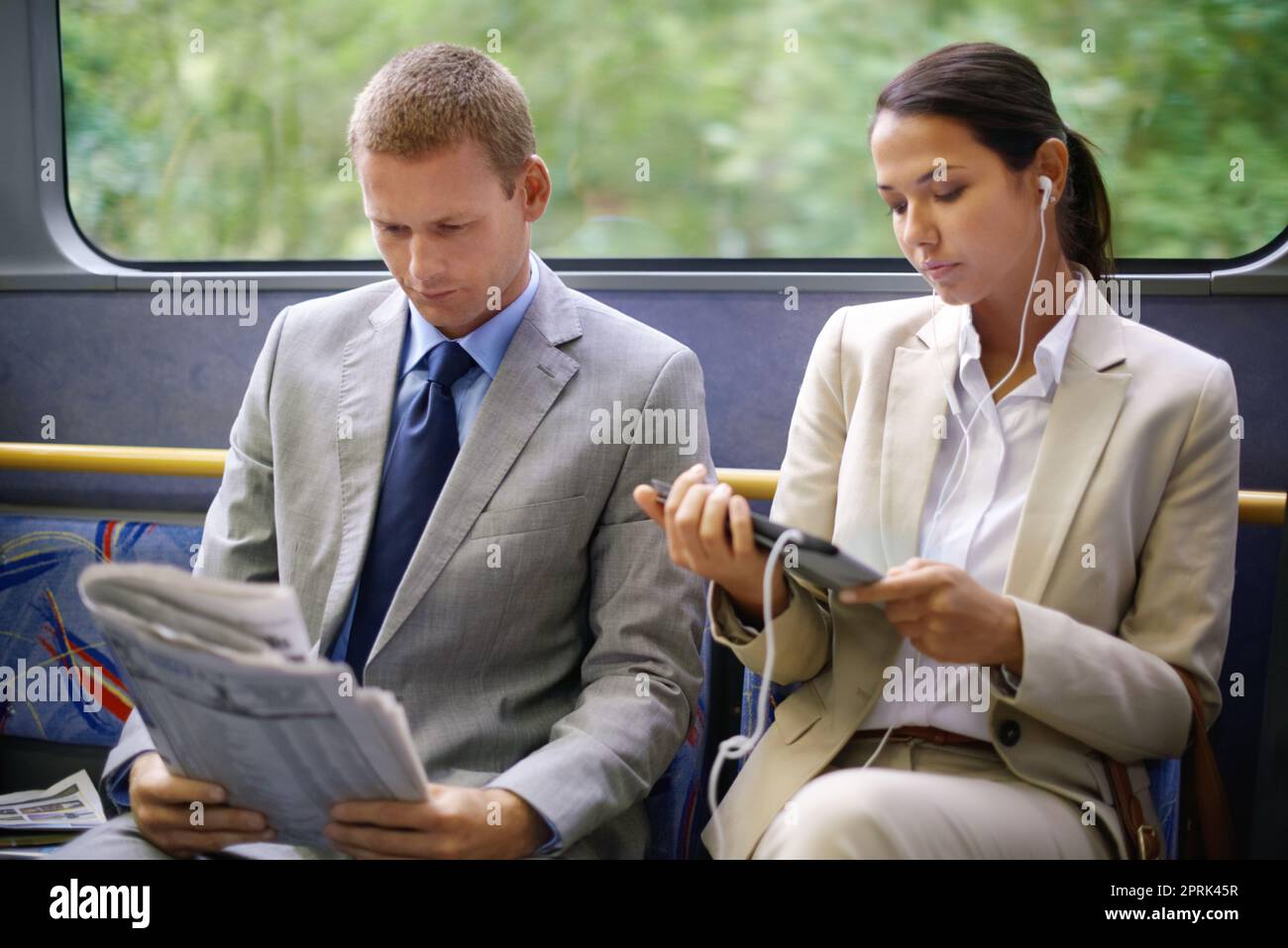 Keeping busy on the bus. young business people commuting to work Stock ...