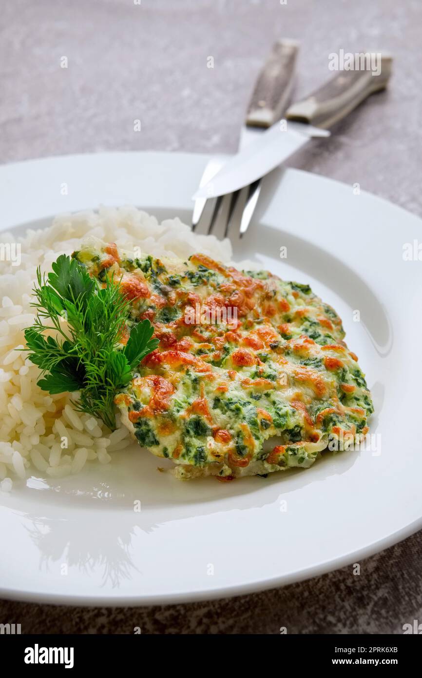Fried hake fillet with spinach, cheese and rice Stock Photo - Alamy