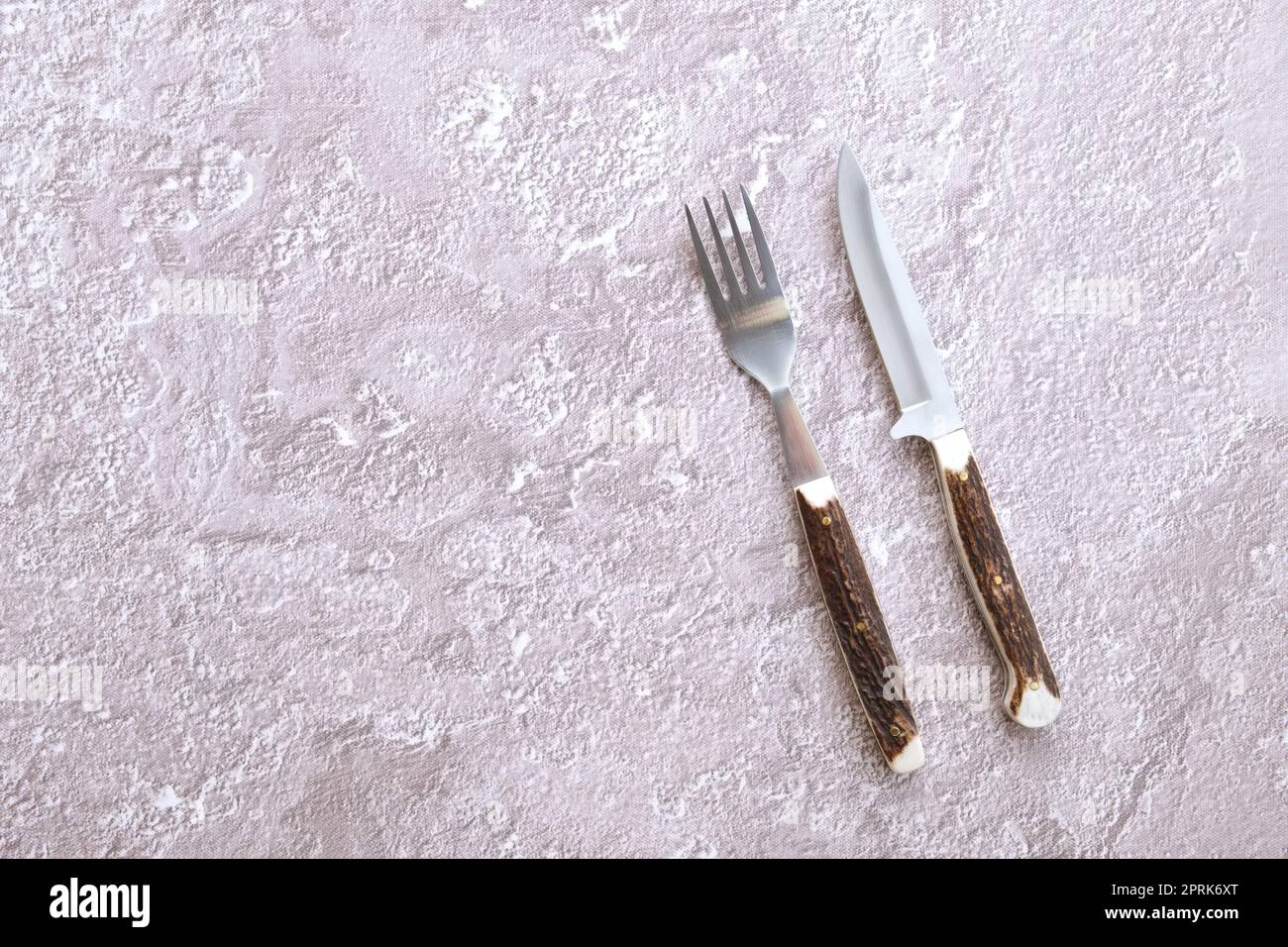 Top view of concrete surface with camping fork and knife with horn ...