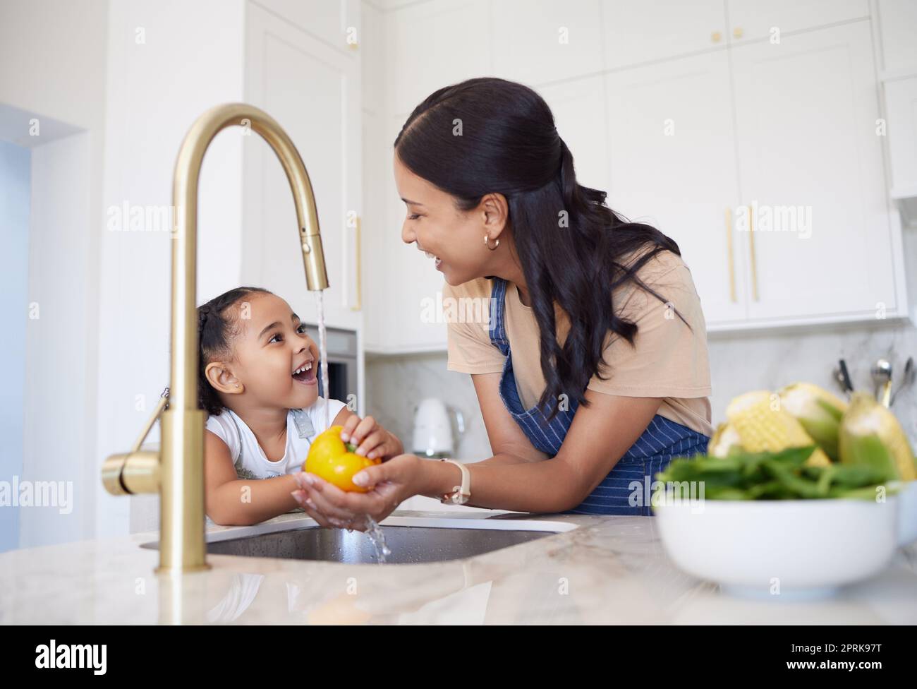 Cooking, mother and child cleaning vegetables for dinner, lunch or diet ...