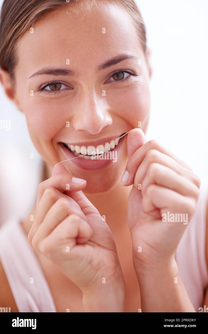 Dental hygiene is a priority. A young woman flossing her teeth Stock ...
