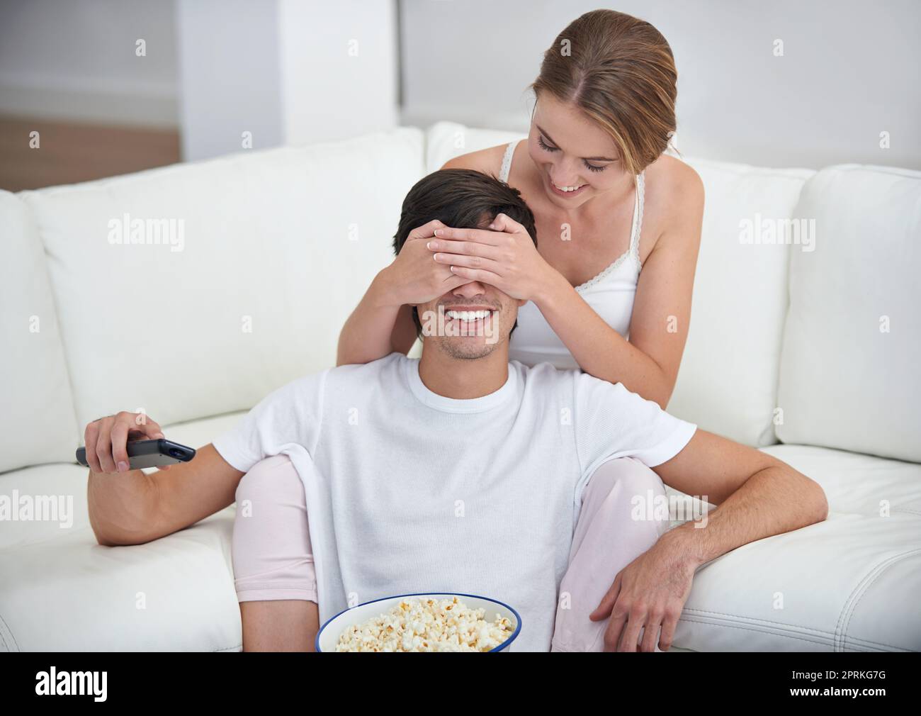 Always playful. a playful young couple watching TV at home Stock Photo ...