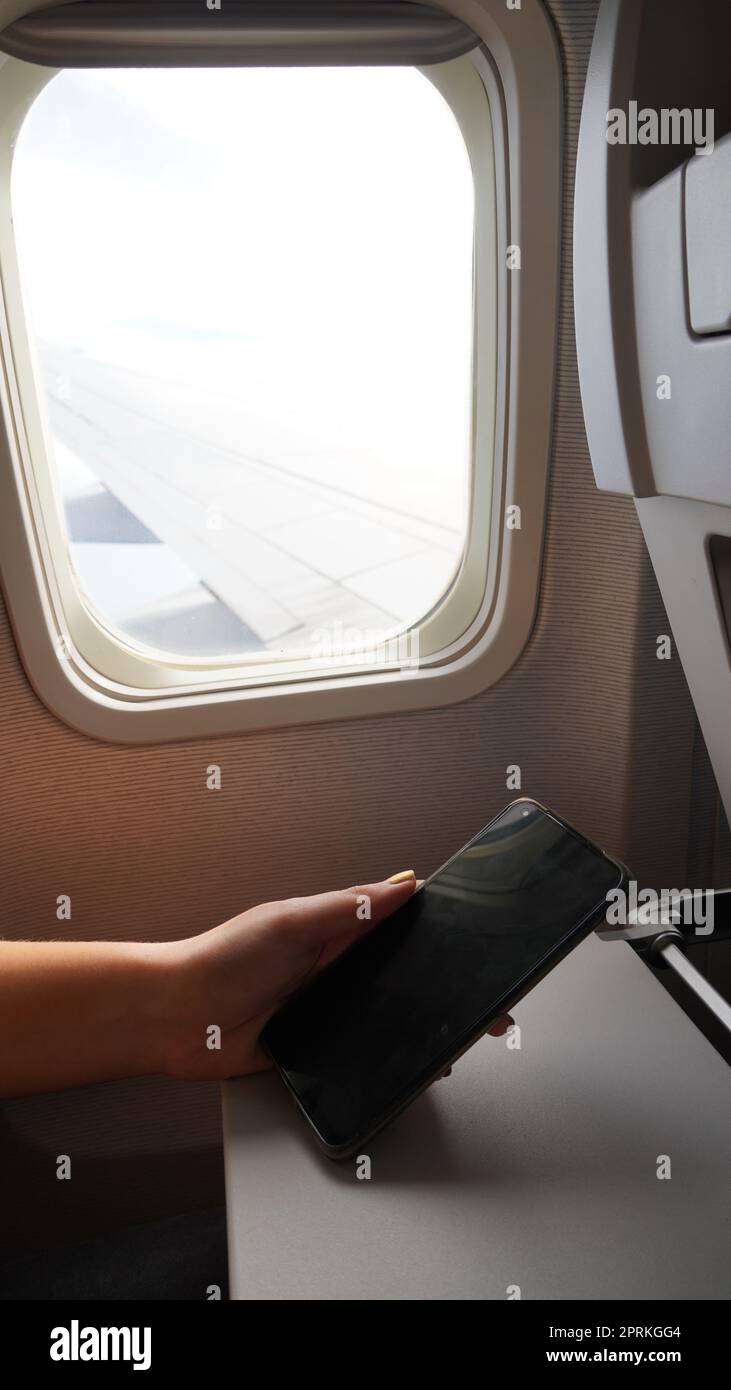 Hand of a passenger with mobile telephone. View through the window of a ...