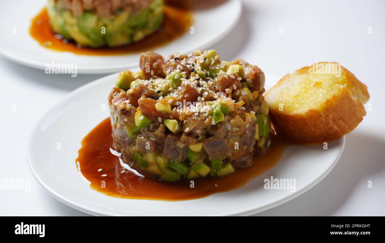 Raw Fish tartar from tuna fillet with hashed avocado, with spices, lime ...