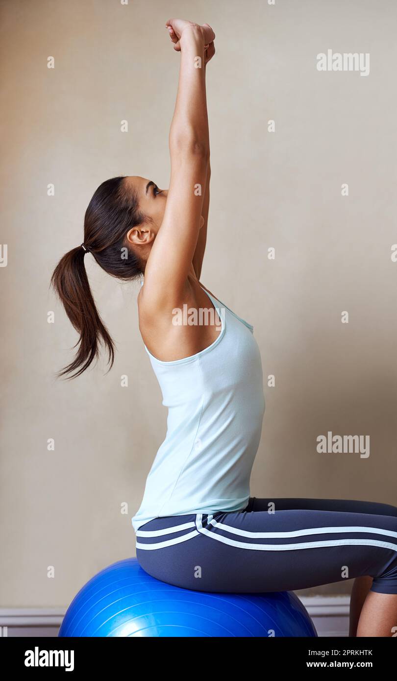 Pilates is part of her daily routine. a young woman doing pilates at ...