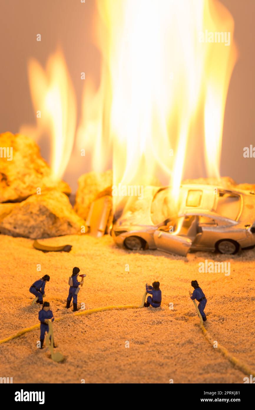 Miniature Firemen at a car accident scene in flames Stock Photo - Alamy