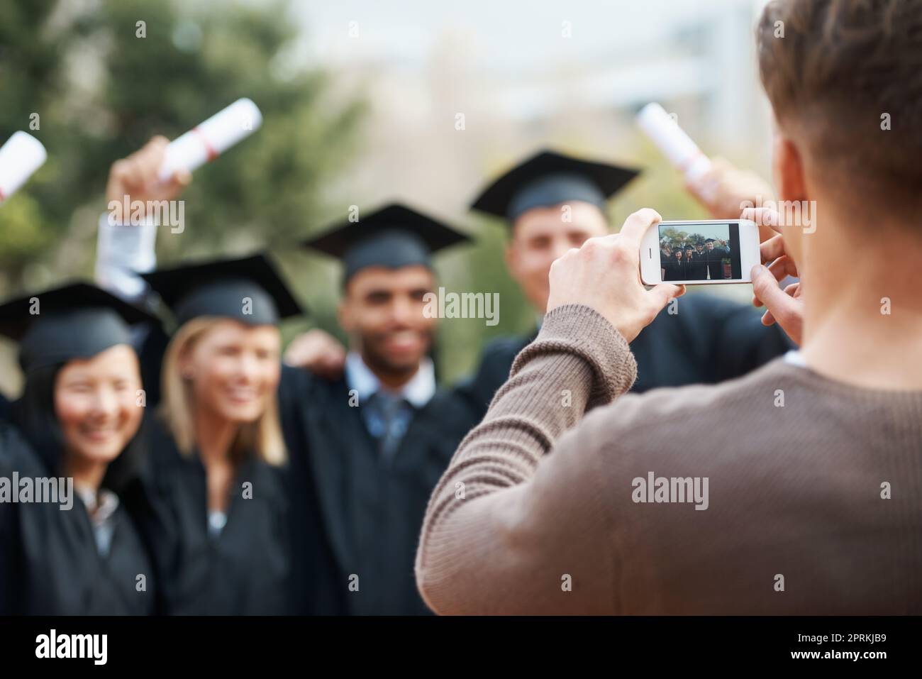 Say Ive graduated. A group of friends posing for a photograph in their togas Stock Photo - Alamy