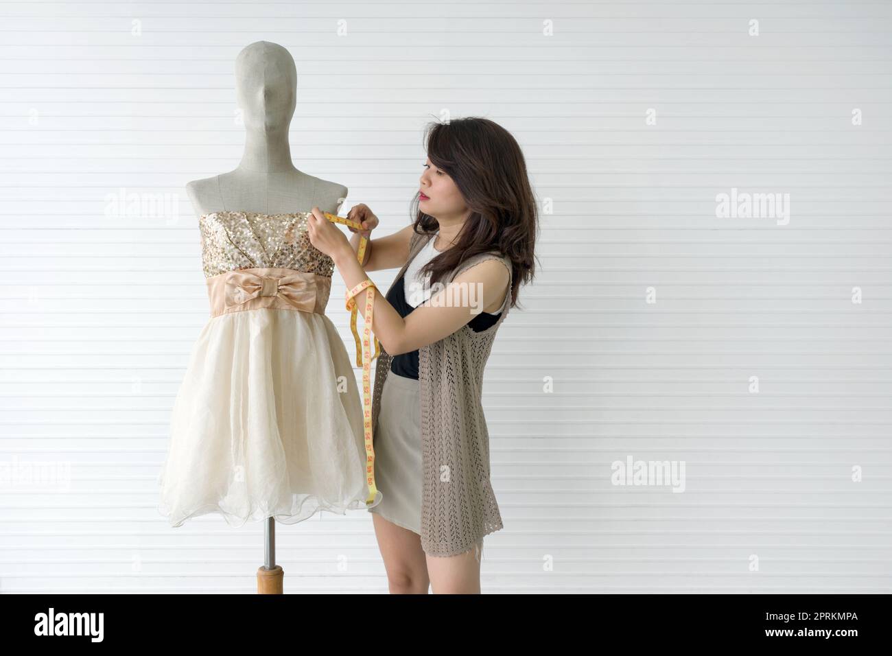 Fashion designer room. Young woman dressmaker using tape measure ...