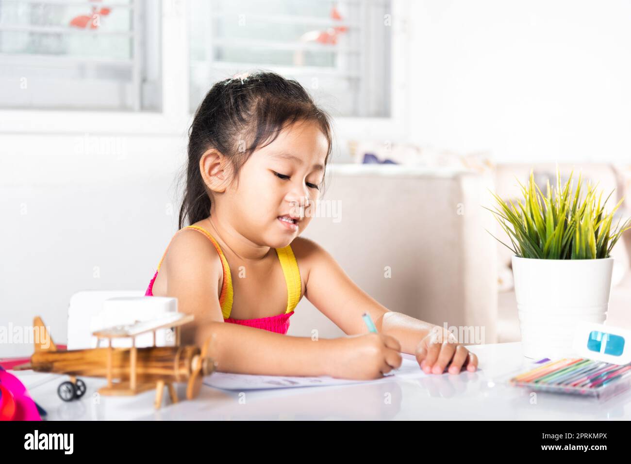 Child little girl drawing cartoon on paper before paint the color ...