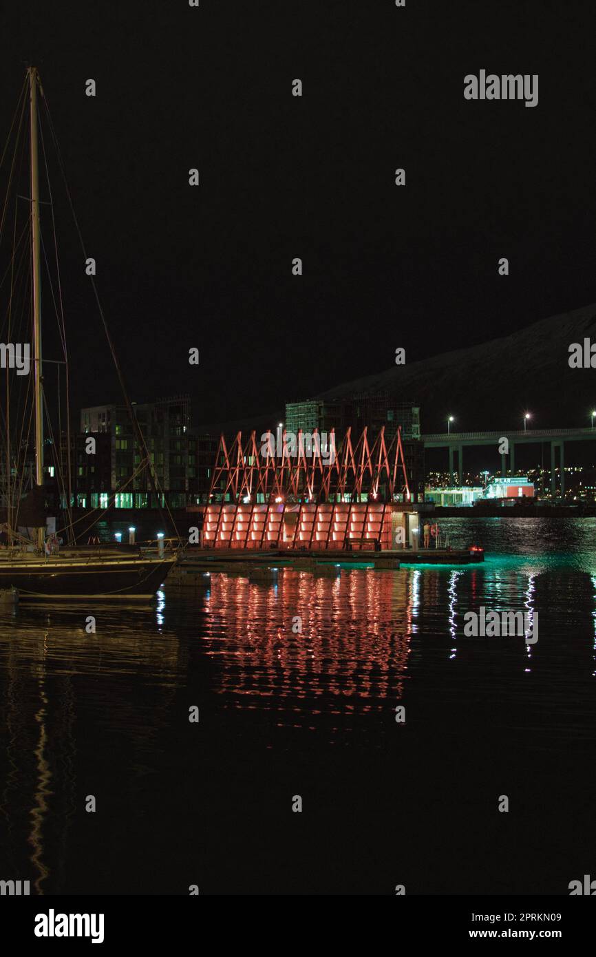 Vertical shot of the Sauna house in Tromso harbor at night. Norway ...