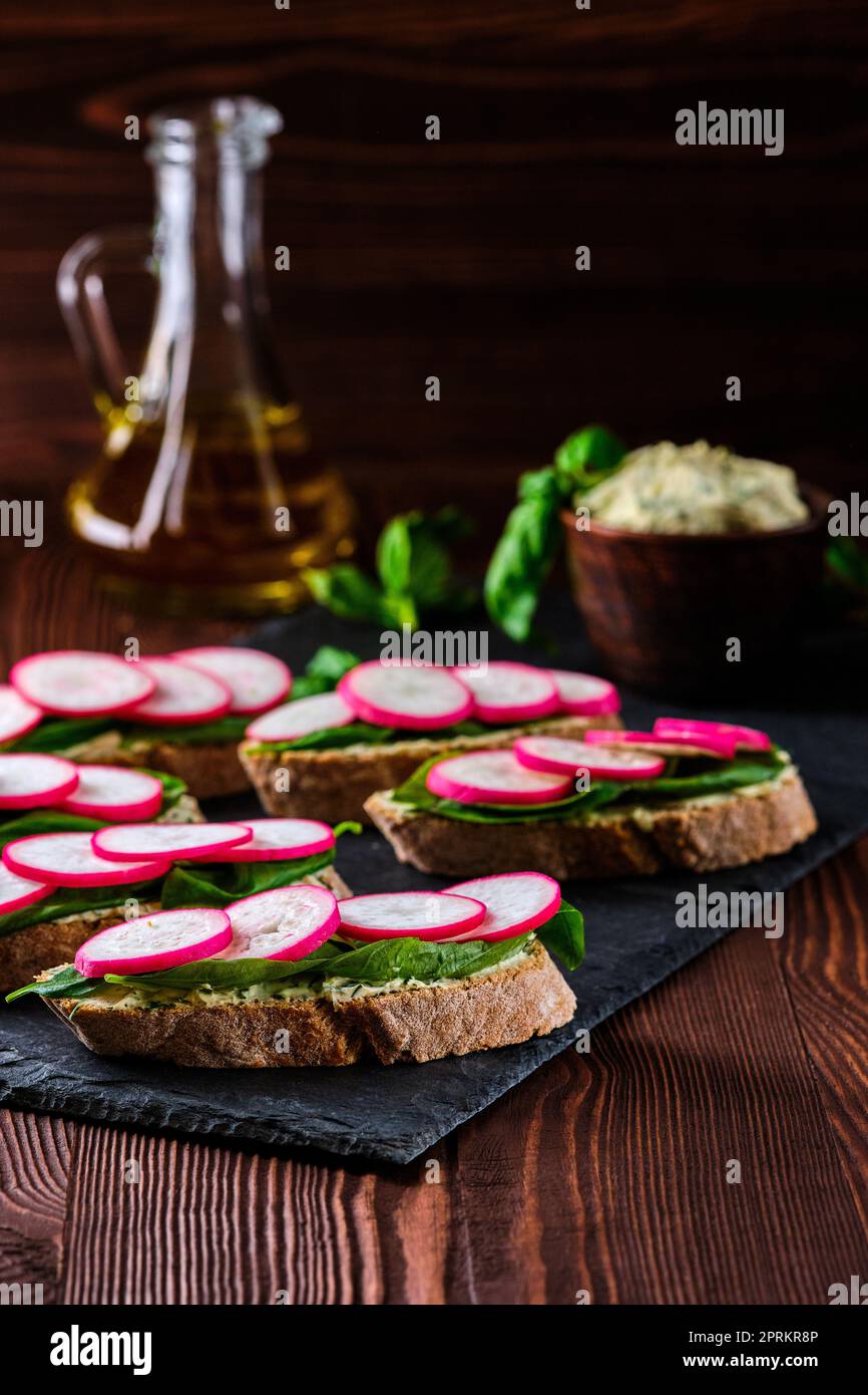 Rustic sandwich with herbal butter, basil and radish Stock Photo - Alamy