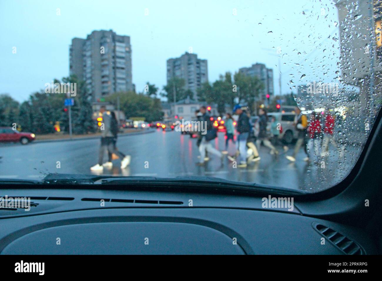 Rain outside window on background of city life. Drops of water dropping ...