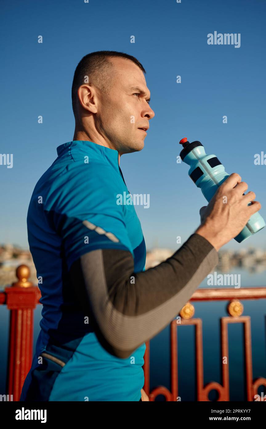 Portrait of healthy athletic middle aged man with fit body holding ...