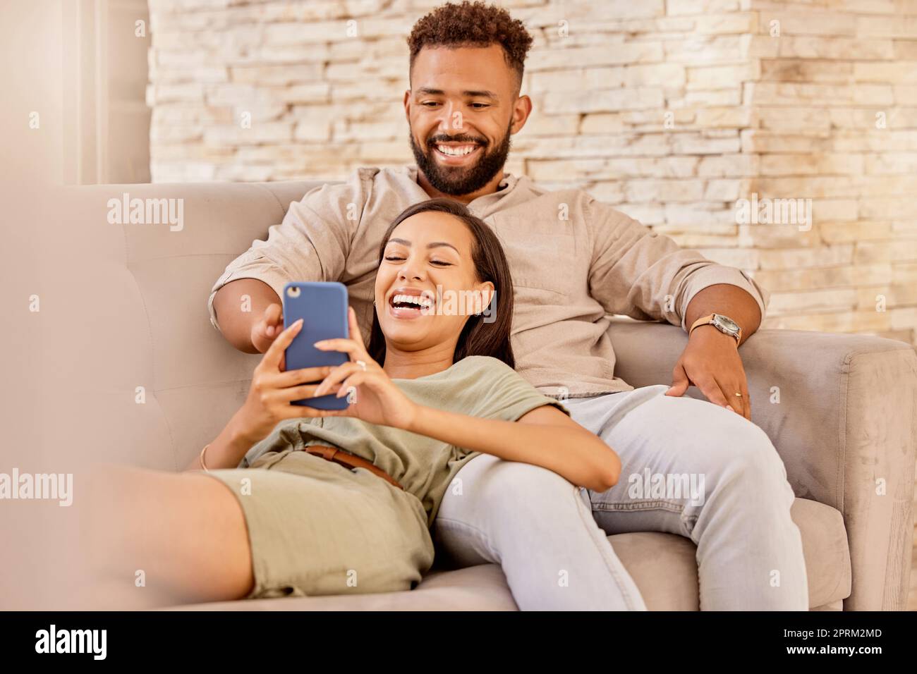Couple, lounge and phone of people on a house sofa with technology ...