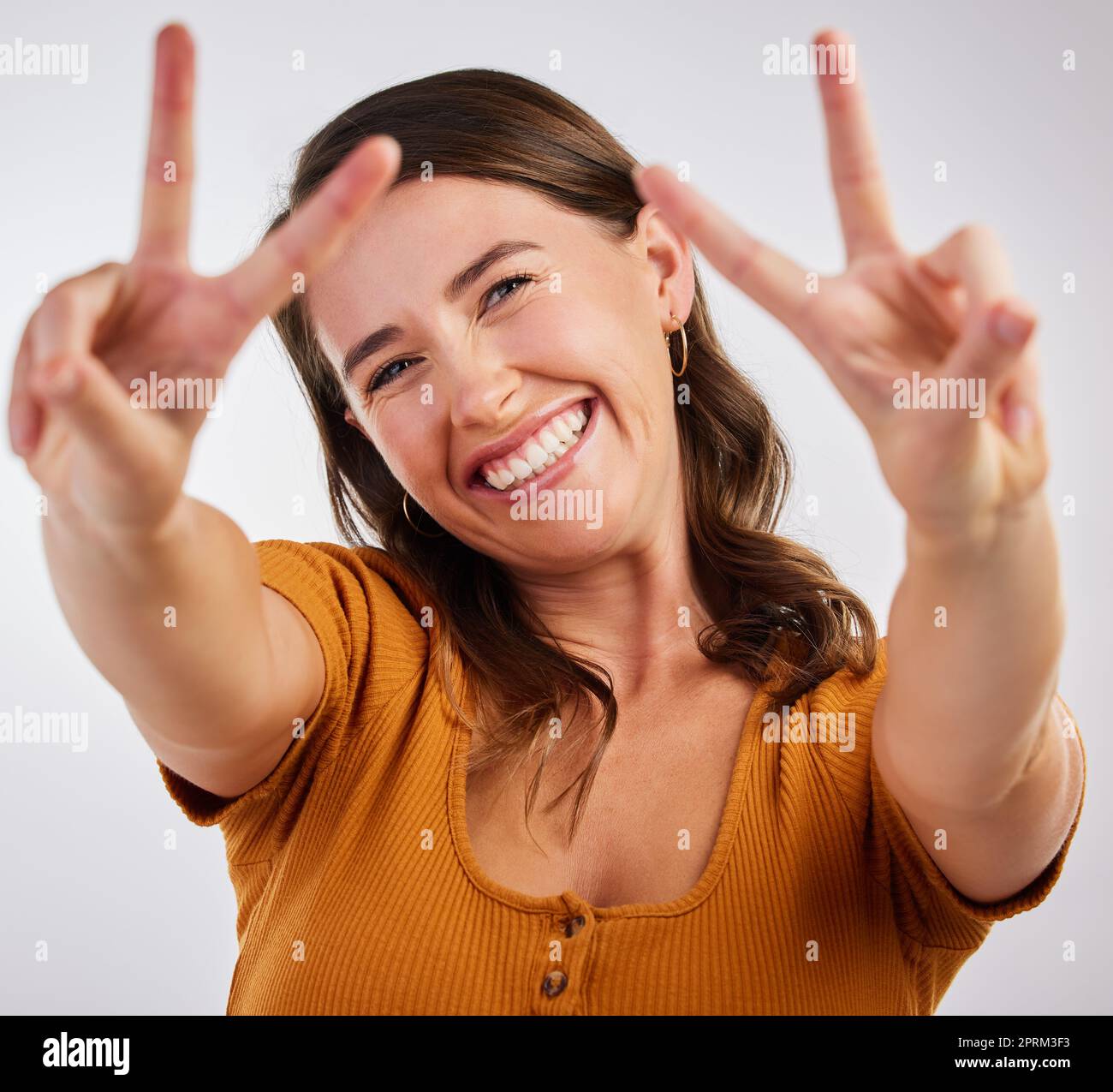 Peace be with you. Studio shot of a young woman showing a peace sign ...