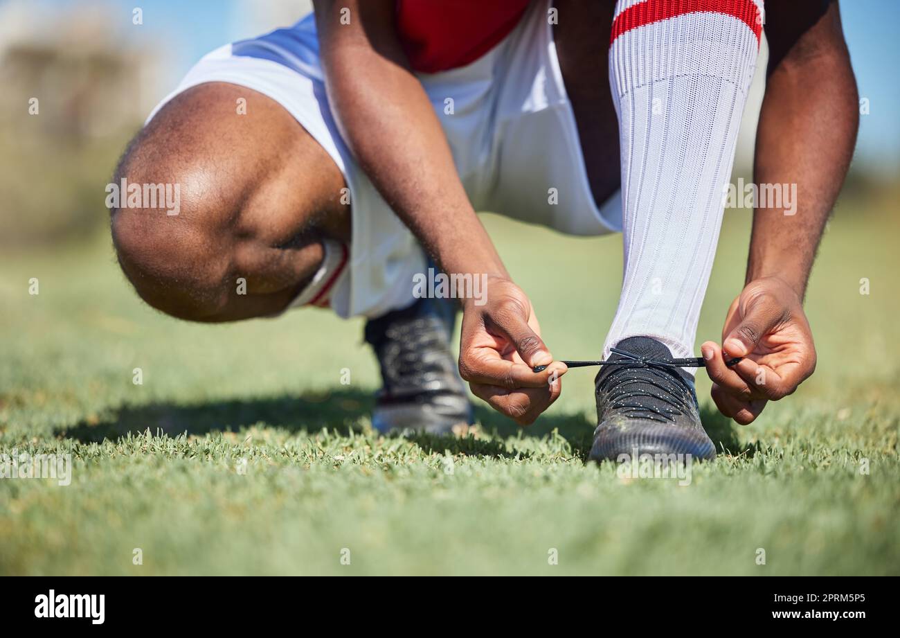 Man tie football shoes lace on soccer field, athlete ready for sports ...