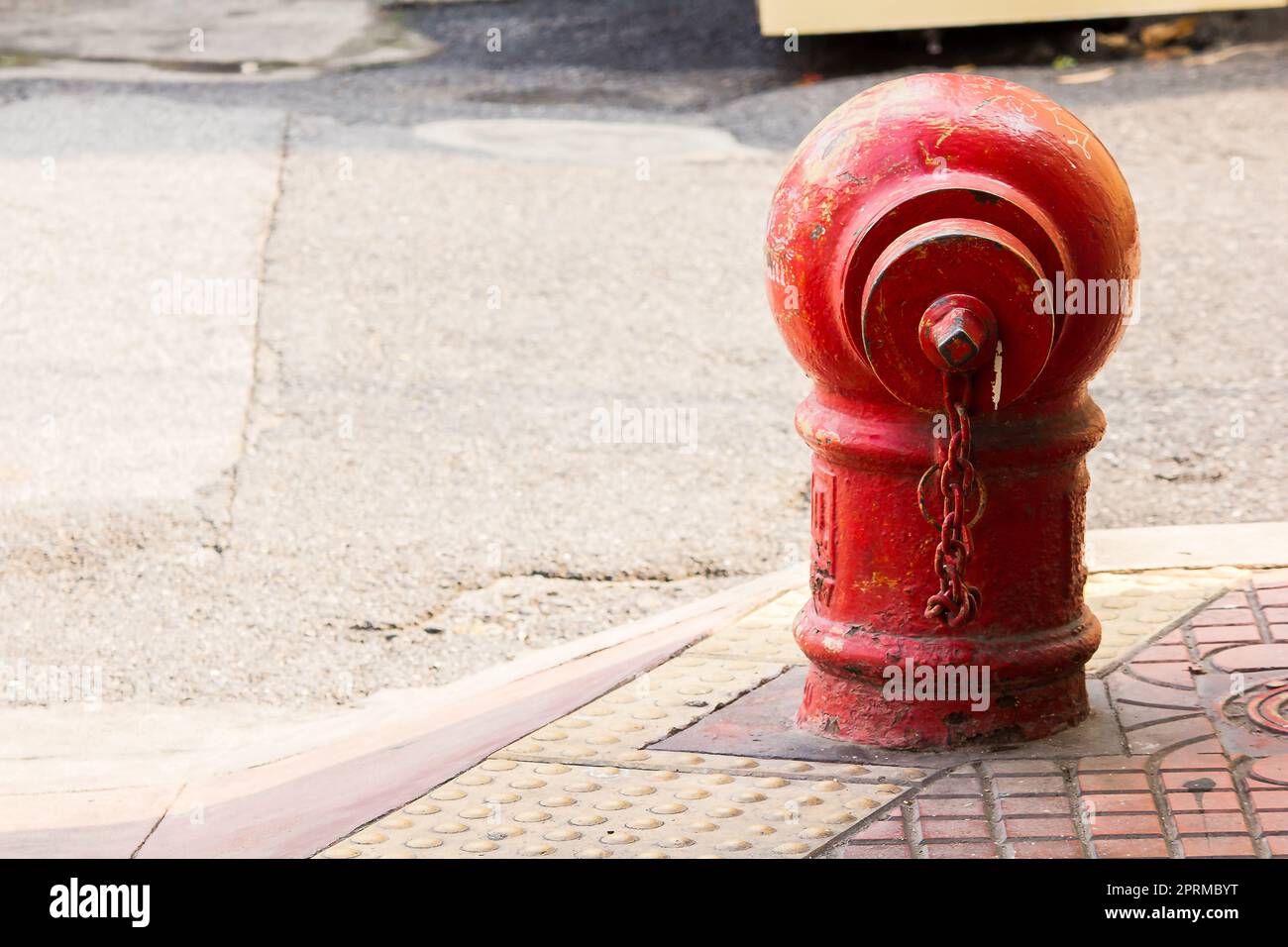 Fire extinguisher is located on the footpath of the road Stock Photo ...