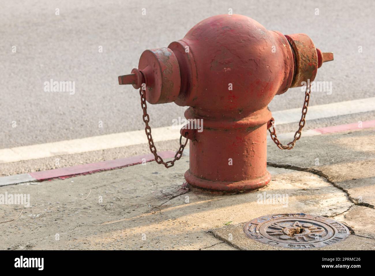 Fire extinguisher is located on the footpath of the road Stock Photo ...