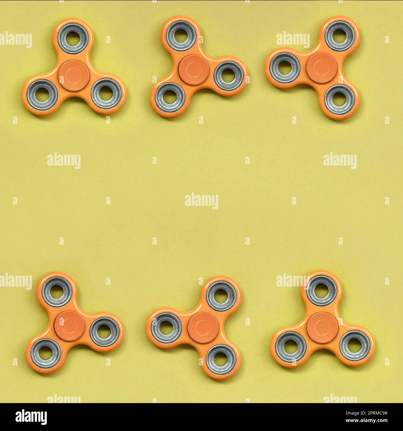 Many orange fidget spinners lies on texture background of fashion ...