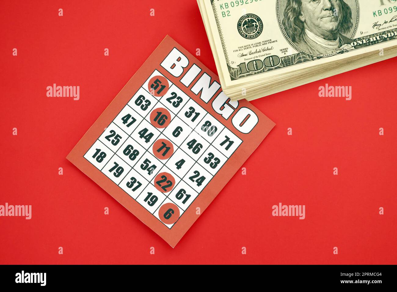 Red bingo board or playing card for winning chips and stack of dollar ...