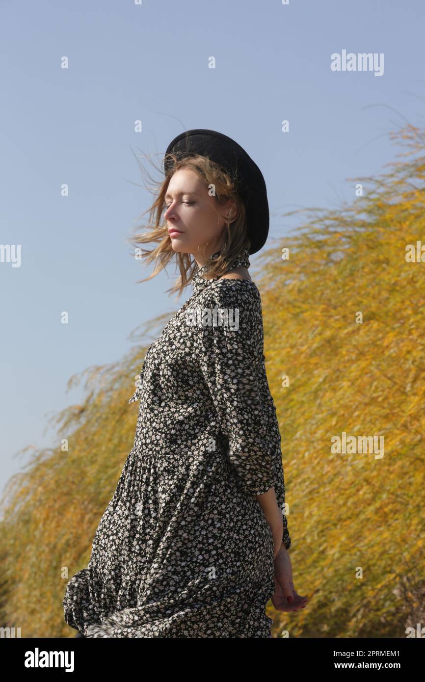 Outdoor fashion portrait of female model in flowy boho floral dress and ...