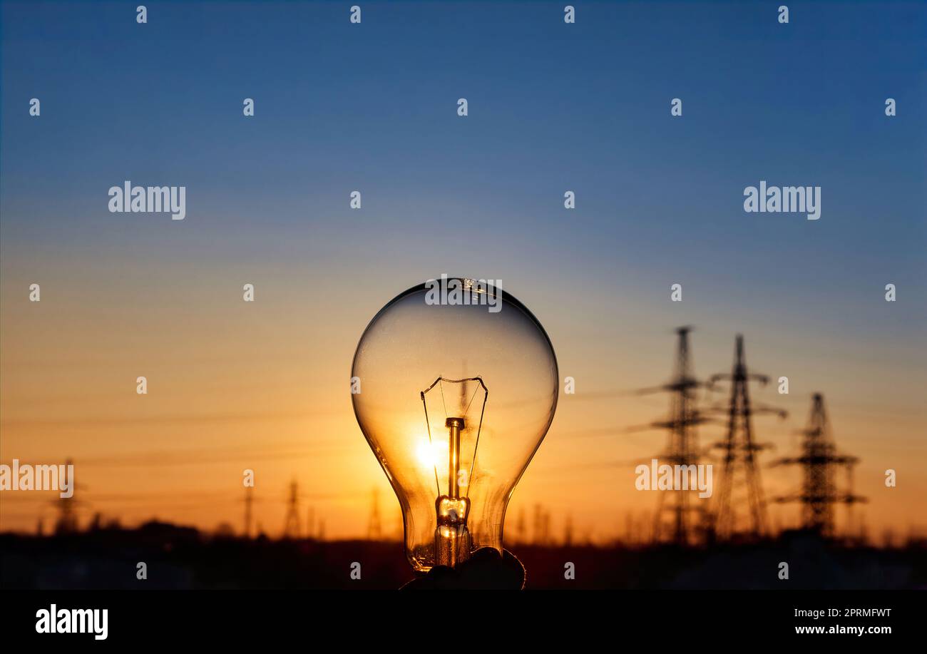 Light bulb with high voltage line on background. Electricity and energy ...
