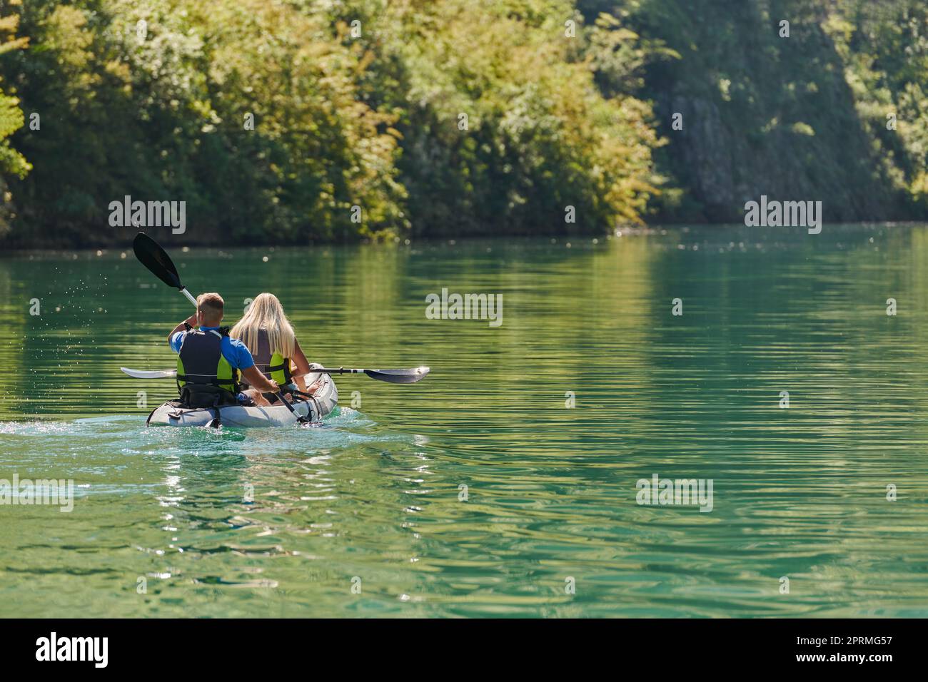 A young couple enjoying an idyllic kayak ride in the middle of a ...