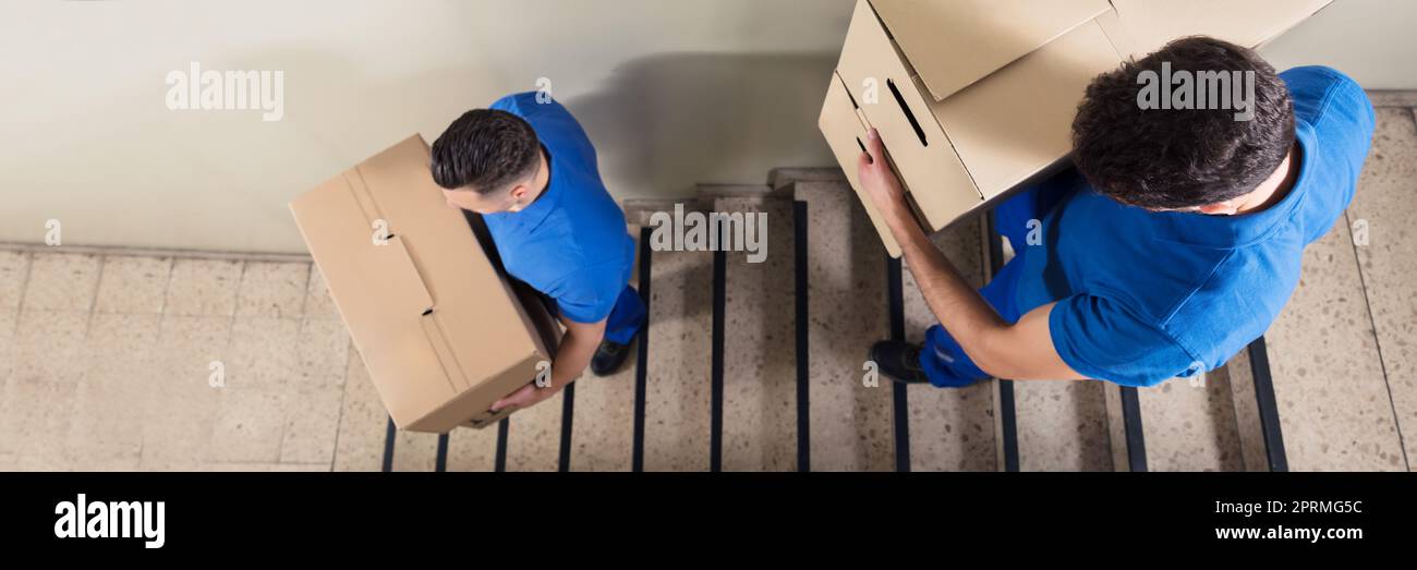 Movers Team Carrying Boxes Down Stairs. Mover Delivery Service Stock ...