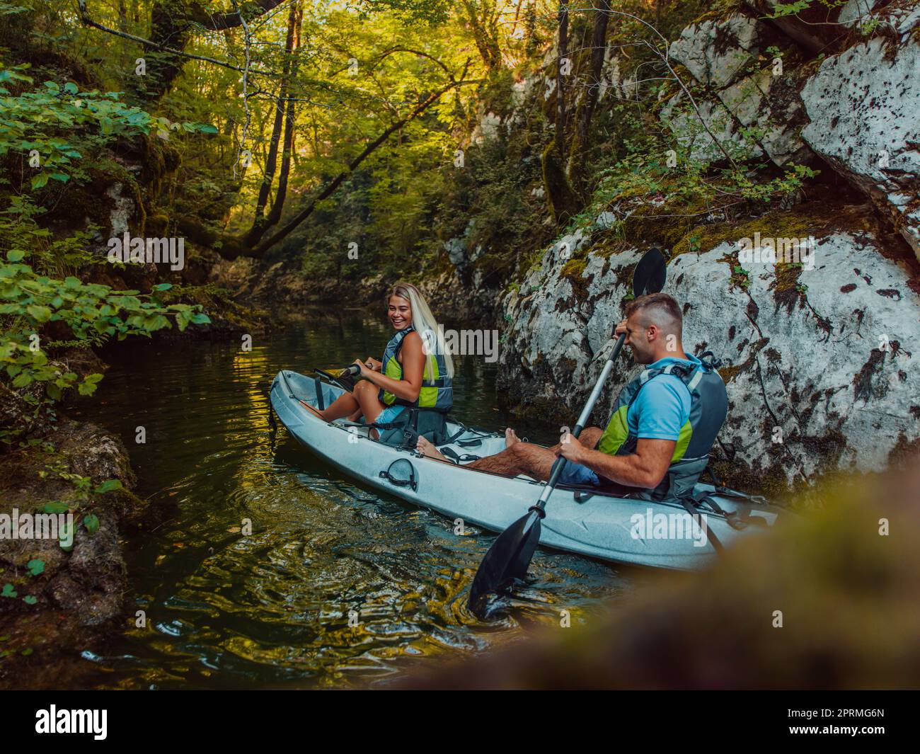 A young couple enjoying an idyllic kayak ride in the middle of a ...